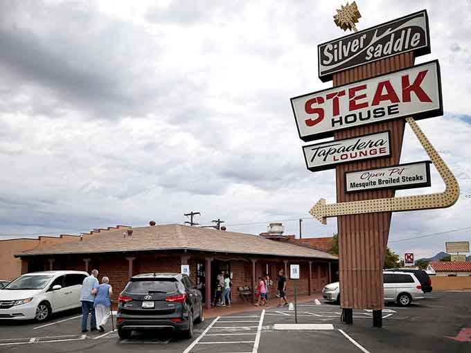 That vintage neon sign towers over East Speedway like a beacon calling hungry travelers to mesquite-grilled paradise.