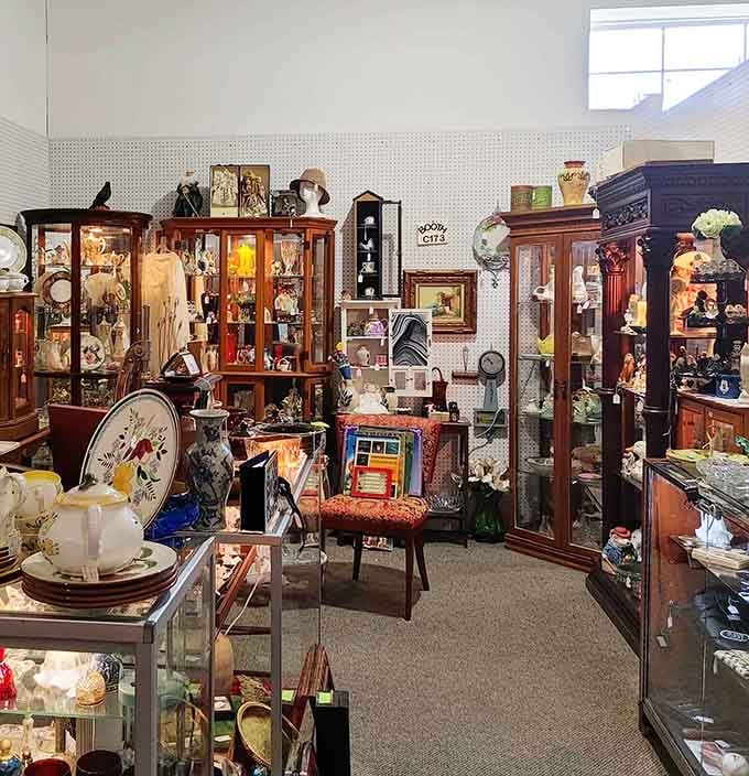 Wooden display cases overflow with delicate china and vintage collectibles, each piece whispering stories from someone's cherished past.