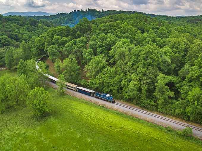 That vintage train snaking through emerald mountains proves the scenic route beats the interstate every single time.