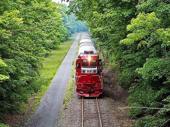 The steam locomotive climbs through autumn mountains trailing white clouds, proving some views never get old no matter how often seen.