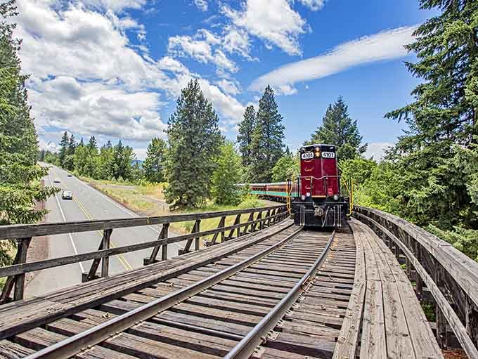 That burgundy locomotive cutting through Oregon's forests looks like it escaped from a Norman Rockwell painting with better scenery.