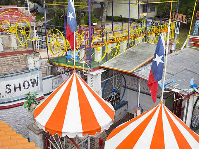 Texas flags wave proudly over this carnival-colored maze where citrus obsession meets pure architectural chaos.