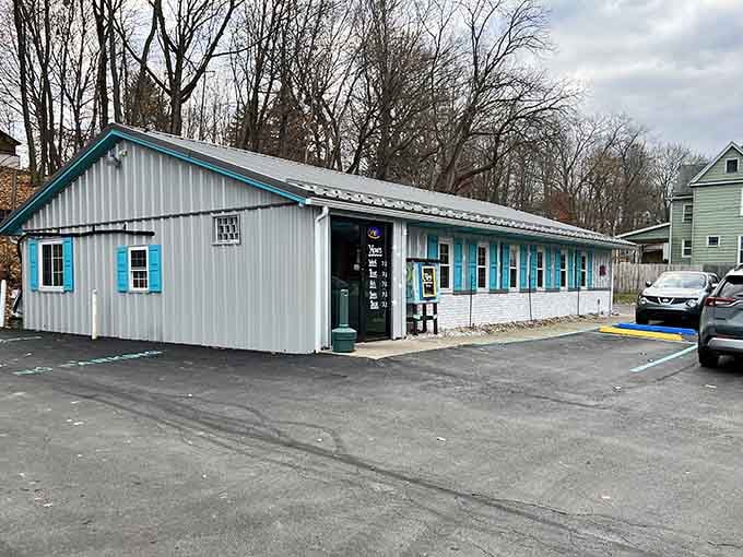 Those cheerful turquoise window frames against gray siding prove the best treasures don't need fancy packaging.