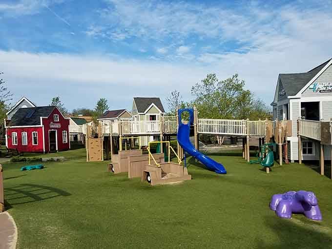 Wide view of the charming village-style playground showing the interconnected buildings and accessible pathways perfect for all children.