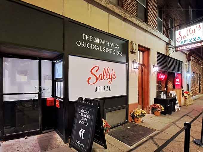 That iconic red script glowing in the night is your beacon to pizza paradise on Wooster Street.