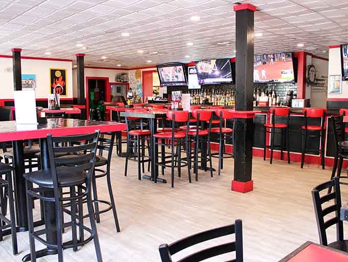 Multiple TVs, a full bar, and red accents everywhere; this is where comfort meets style without any pretension whatsoever.