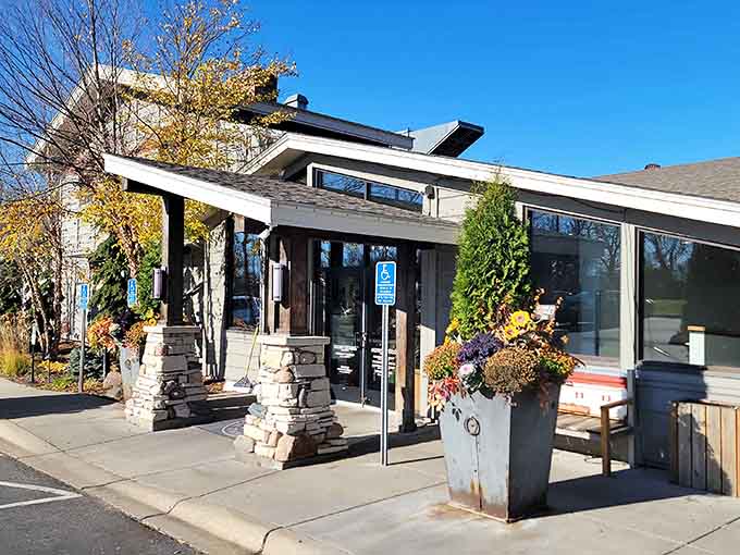 Stone pillars and autumn blooms frame the entrance to your next favorite dining destination in Long Lake.