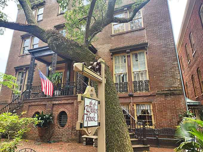 That historic brick facade and wrought-iron balcony whisper "authentic Savannah" louder than any tourist brochure ever could.