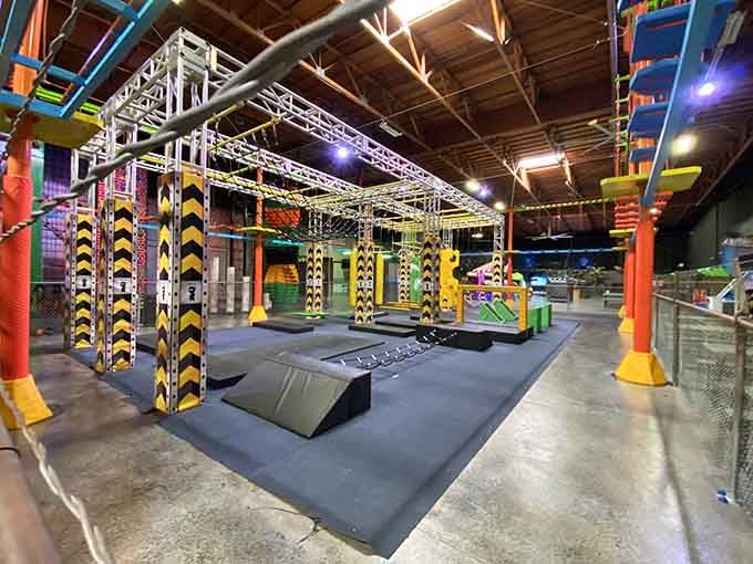 Yellow and black striped obstacles tower overhead like a jungle gym designed by someone who really understood fun.