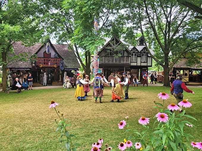 Dancers twirl in period costume while Tudor buildings frame the scene like a storybook come alive.