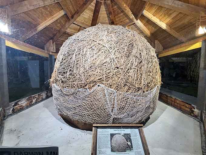 The wooden gazebo interior frames this magnificent sphere like a temple built to honor humanity's strangest impulses.