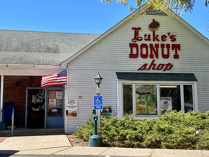 That hand-painted sign and American flag combo hits different when you know the donuts inside are worth the early wake-up call.