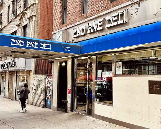 That blue awning is your beacon to sandwich nirvana, where Hebrew letters spell out delicious destiny.