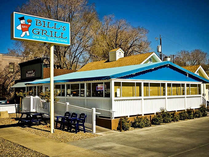 That retro sign and those cheerful blue chairs outside are basically screaming "come eat something delicious and regret nothing."