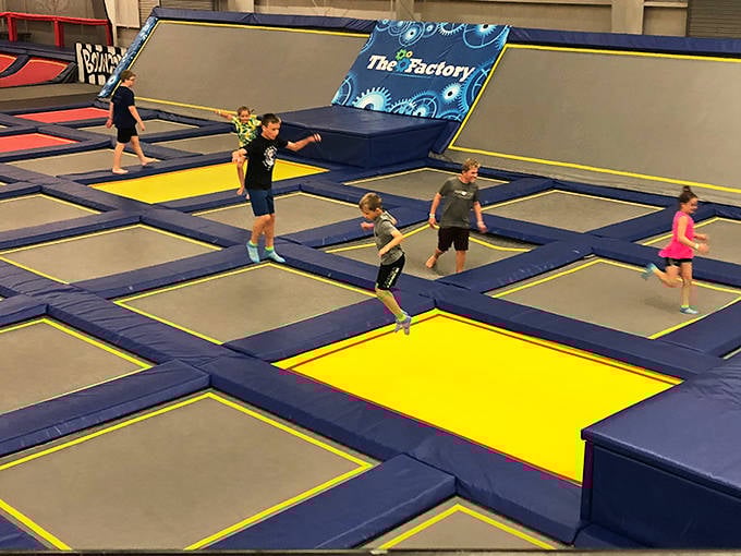 Kids racing across interconnected trampolines like they're training for the Olympic bouncing team that doesn't exist yet.