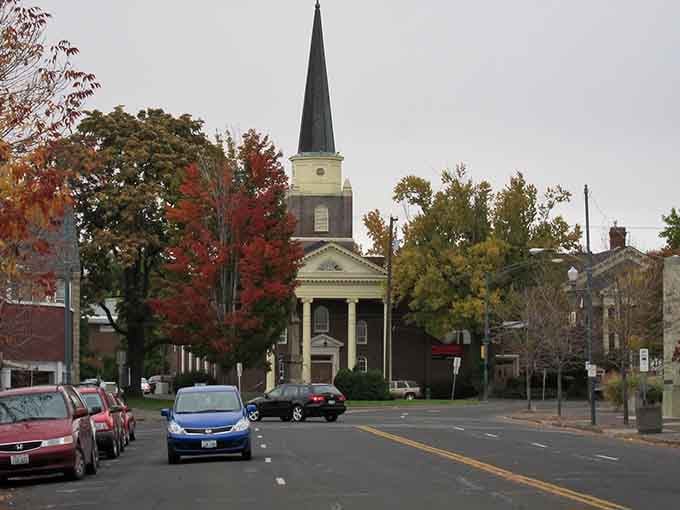 That church steeple rising above fall foliage proves some architecture never goes out of style, unlike your bell-bottoms.
