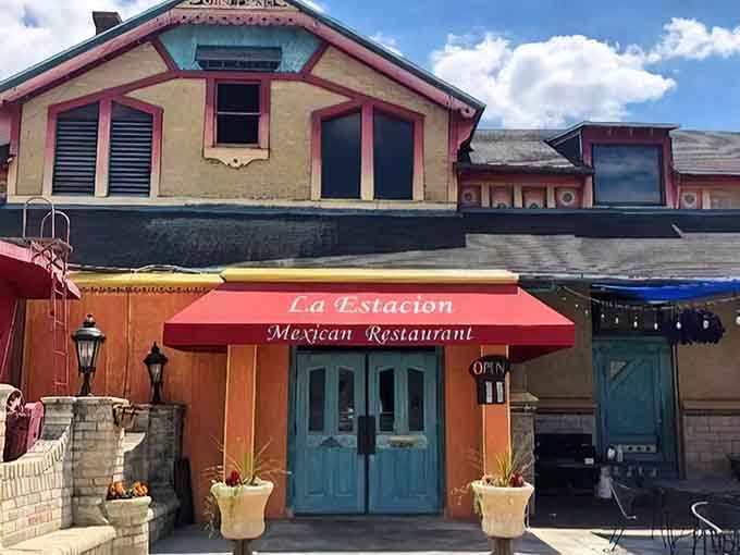 That red awning beckons like a warm invitation, promising authentic flavors behind those turquoise doors at this converted depot.