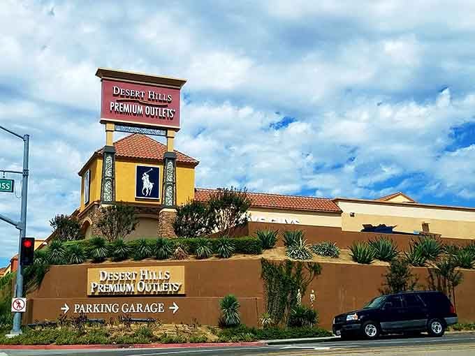 That iconic entrance with its terra-cotta roof and mountain backdrop promises retail therapy with a side of California sunshine.