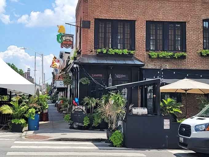The cheerful signage and lush greenery create an inviting corner that feels like a neighborhood secret worth sharing.
