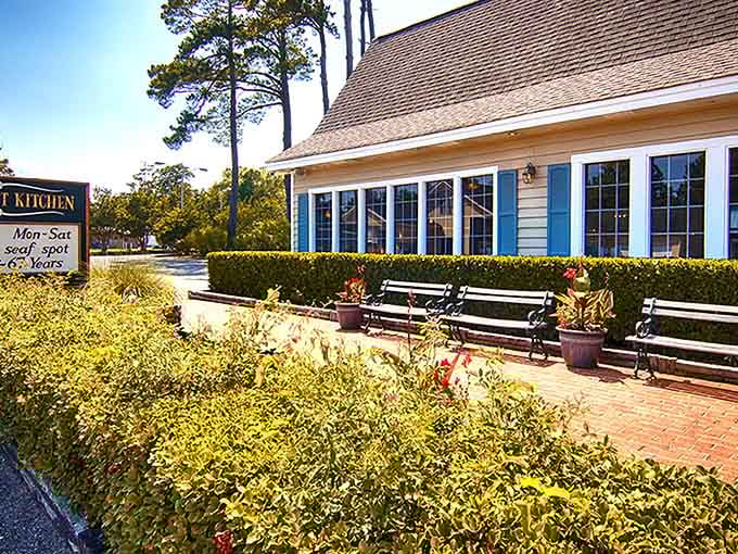 The brick walkway and welcoming benches outside Lee's Inlet Kitchen promise the kind of coastal charm that makes waiting for a table feel like part of the experience.