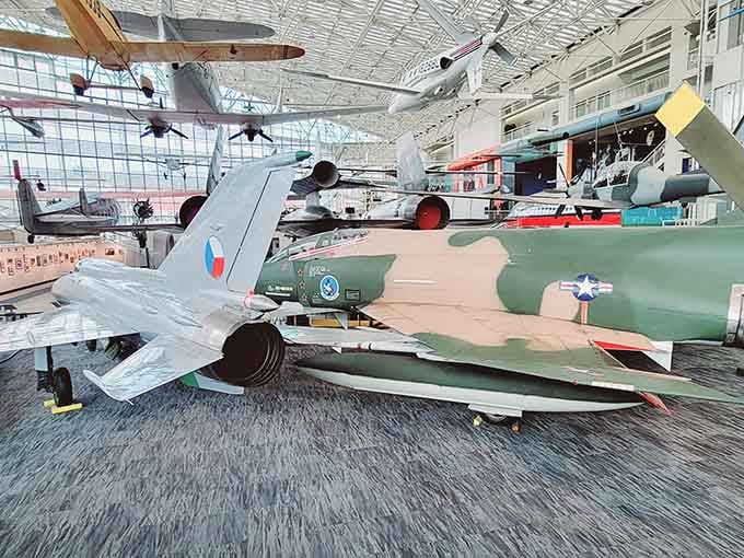 Military jets from different eras sharing the same floor like an international aviation reunion nobody wanted to miss.