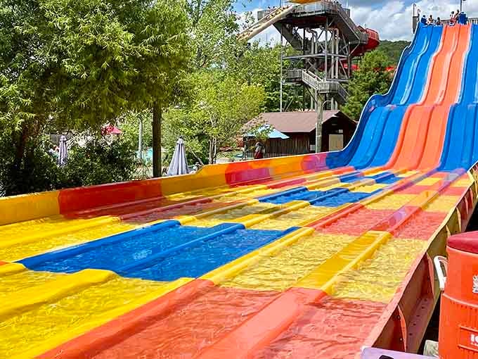 Those rainbow racing slides look like someone melted a box of crayons and turned it into pure summer joy.