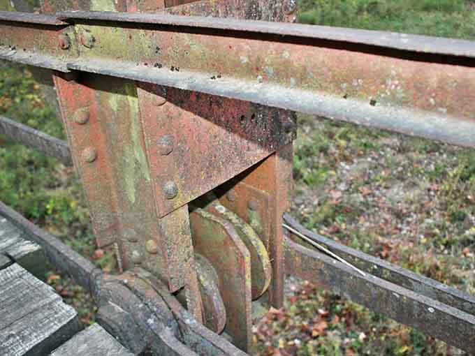 Rust blooms on every rivet and bolt, nature's patina transforming functional hardware into accidental art installations.