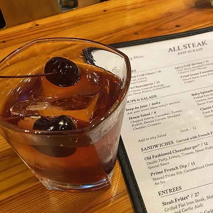 An old fashioned with cherries waiting patiently, the perfect liquid companion for contemplating your steak order ahead.