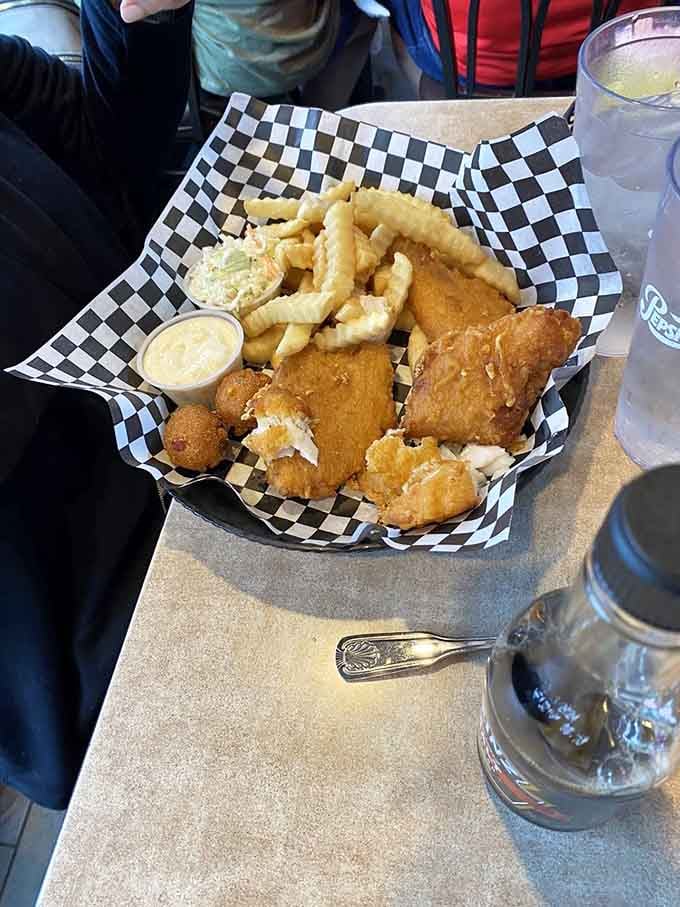 Fish and chips served in a checkered basket with hush puppies: classic diner food done right without any unnecessary complications or pretension.