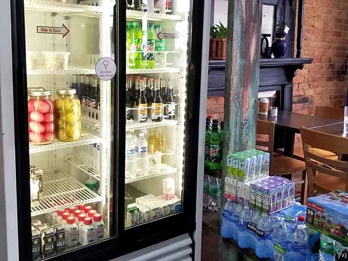 A well-stocked beverage cooler next to exposed brick; because even paradise needs practical touches and cold drinks.