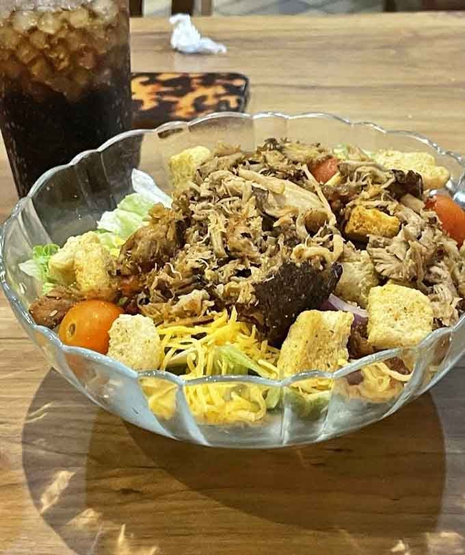 Fresh greens meet championship smoked pork in a salad that actually makes vegetables exciting somehow.