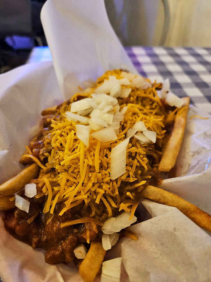 Chili cheese fries piled so high they could qualify as a small mountain range in a very delicious national park.