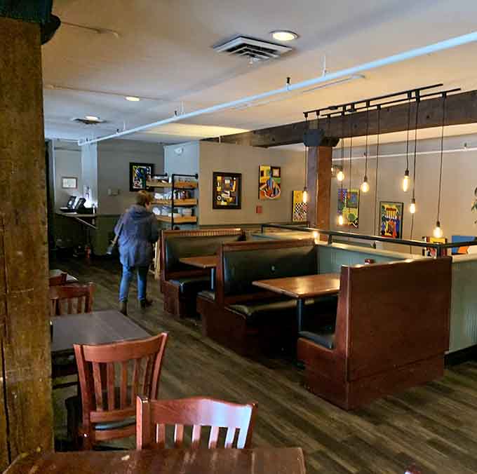 Booth seating and pendant lights create an atmosphere where lingering over another slice feels absolutely mandatory and justified.