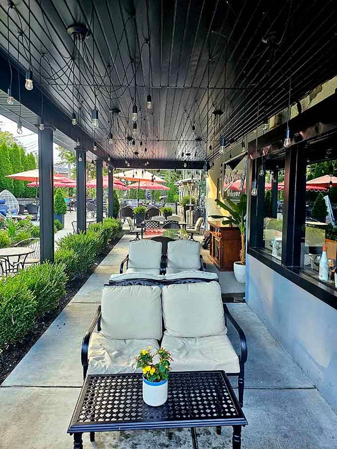 Plush lounge seating under string lights transforms outdoor dining into something resembling a Mediterranean resort vacation minus the airfare.