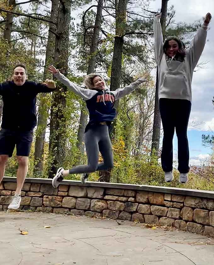 Joy looks like three people jumping on a stone wall with mountains watching their shenanigans.