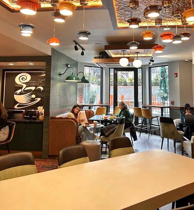 The eclectic lighting fixtures overhead create that perfect coffeehouse ambiance where hours disappear without you noticing at all.