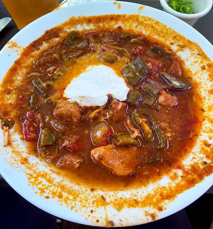 Chili verde swimming in flavorful broth, topped with sour cream and ready to warm you from your taste buds to your toes.