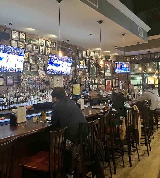 The bar area buzzes with energy, framed photos, and flat screens showing the game while pizzas emerge.