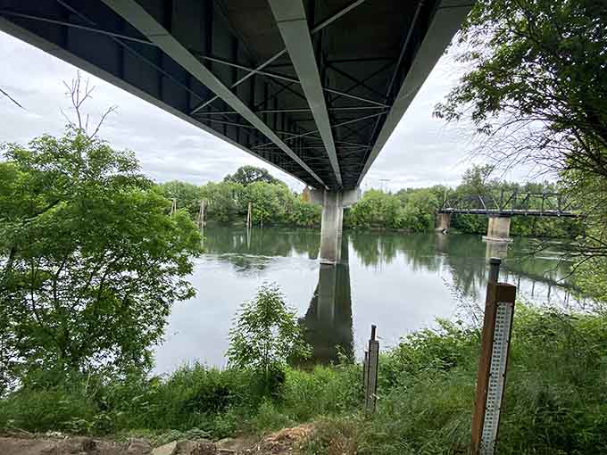The view from beneath the bridge offers a different perspective, where concrete pillars meet their watery reflections.