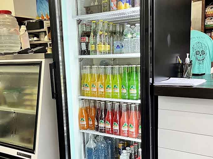Colorful Jarritos bottles lined up like edible rainbows, offering nostalgic Mexican soda flavors that pair perfectly with every taco.