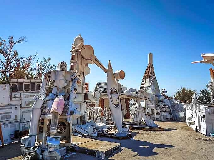 Appliance sculptures rise from the sand like a robot uprising decided to pause for artistic contemplation.
