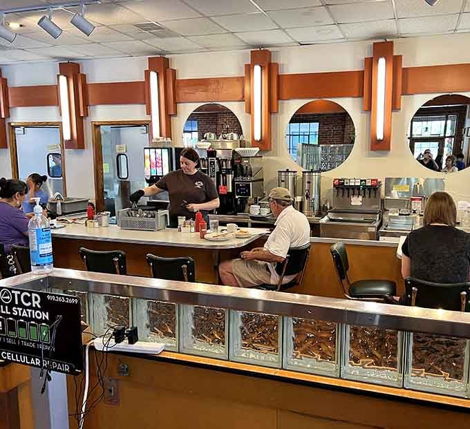 Counter seating with circular mirrors overhead offers prime people-watching real estate for solo diners and coffee contemplators alike.