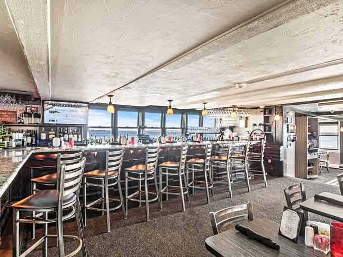 The bar area stretches along windows overlooking the water, where every seat comes with a view and liquid refreshment.