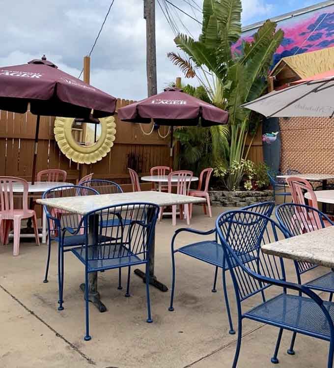Outdoor seating where pink umbrellas and palm trees remind you that paradise doesn't require a passport.