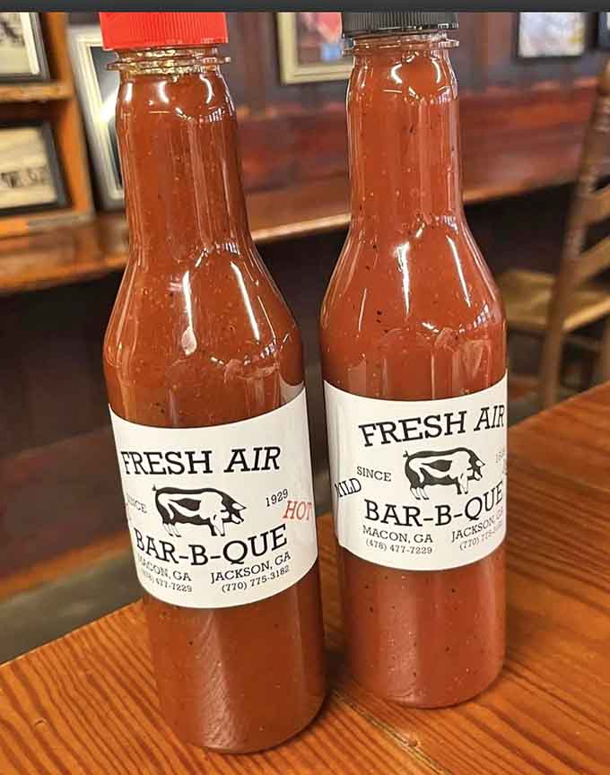 Mild and hot sauce bottles standing ready like flavorful soldiers waiting to enhance your barbecue experience.