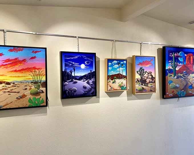 Desert-themed paintings line the gallery walls, showcasing the artistic vision that drives this entire creative endeavor.
