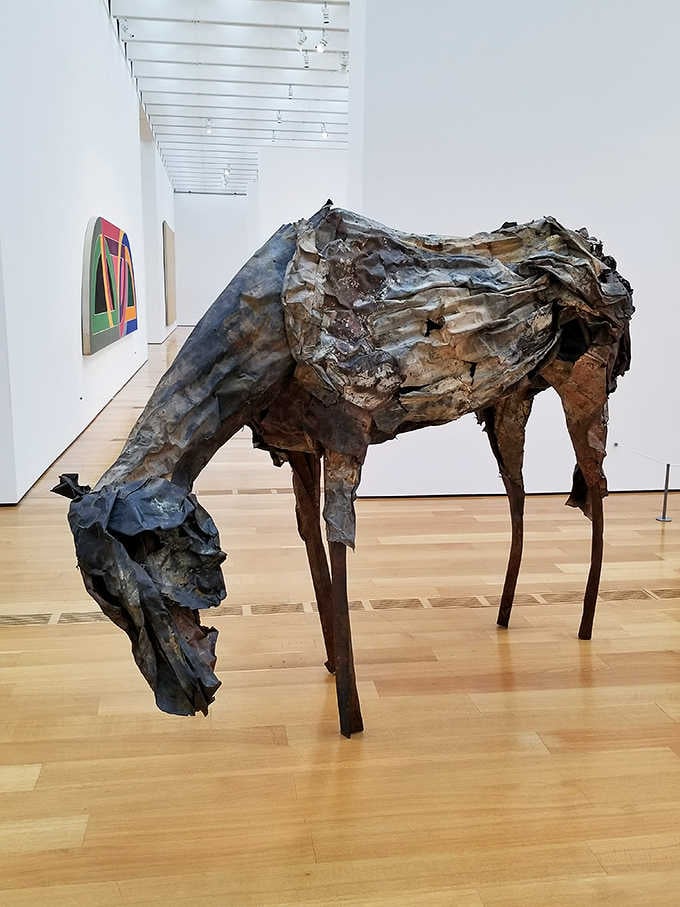 This weathered horse sculpture carries stories in every crease, standing noble despite its battle scars.