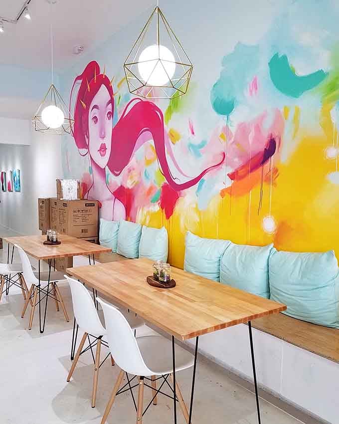Pastel cushions soften the seating while that magnificent mural adds drama worthy of any museum wall.
