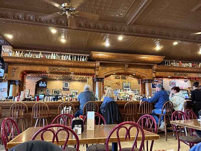 The bar stretches invitingly with ornate woodwork overhead, where strangers become friends over cold beers and good stories.