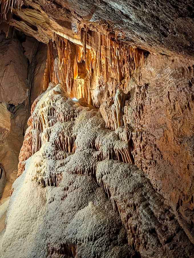 Flowstone formations cascading down the walls like frozen waterfalls that forgot to melt for millennia.